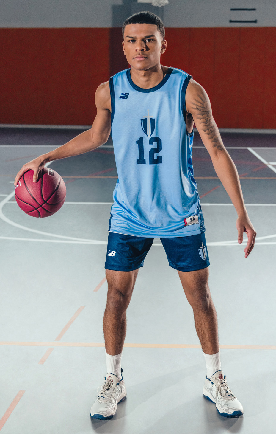 A male athlete wearing a custom New Balance basketball uniform.
